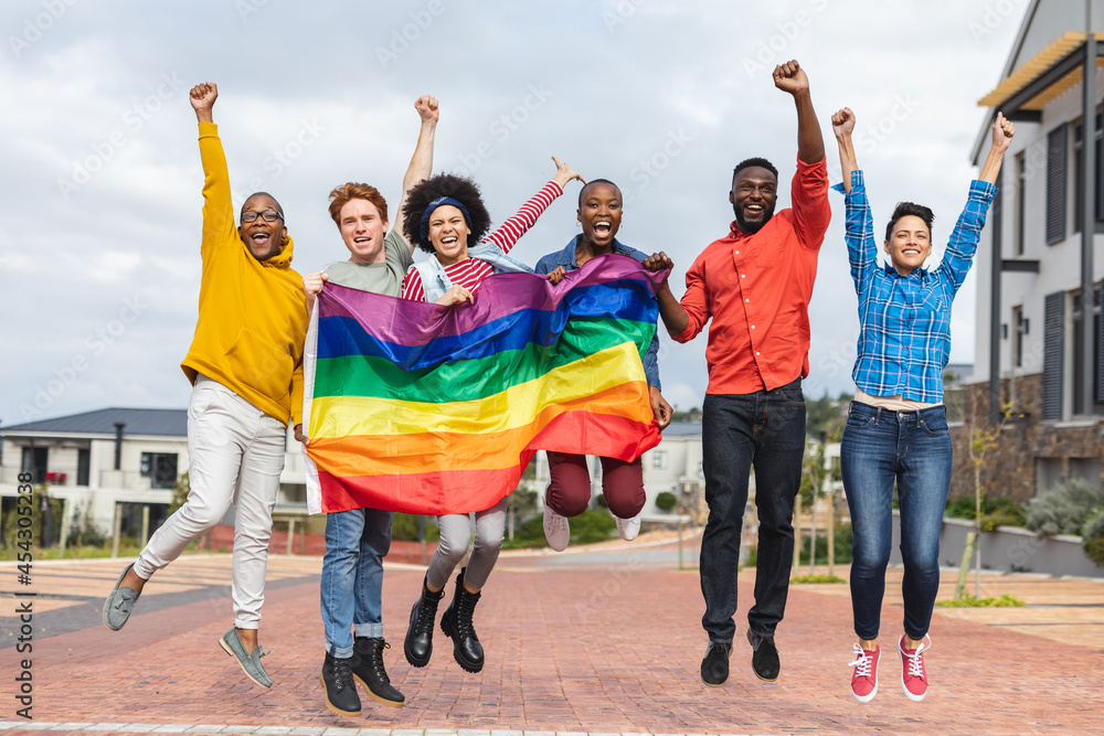 Smiling diverse group of people holding lgbt flag at protest march ...