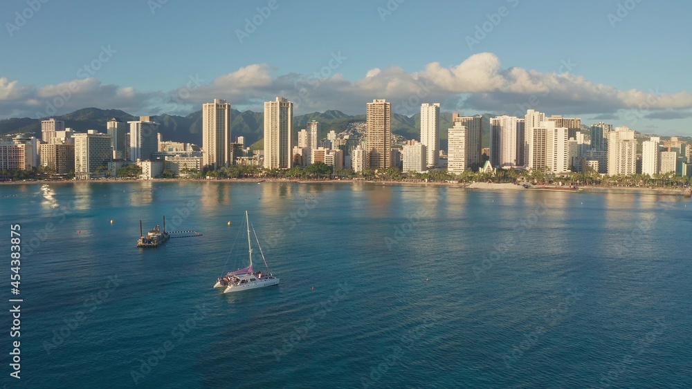 Panning aerial drone slowly flying over a colorful Honolulu Skyline ...
