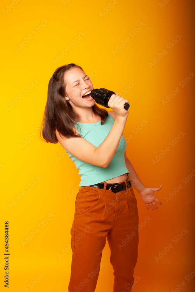 girl brunette teenager, 15 years holding a microphone in his hands ...