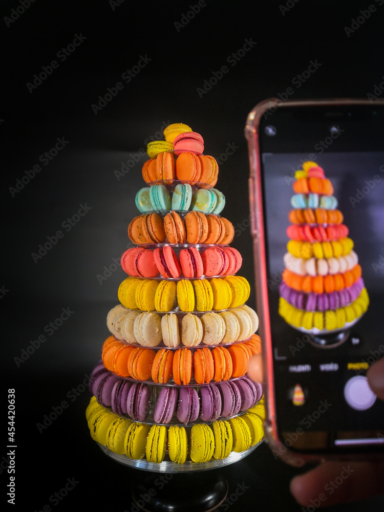 Ephone taking a picture of a large pyramid of delicious macaroons with ...