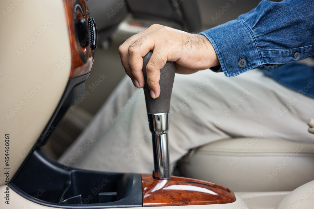 Young man getting new car and his hand control the stick shift ...