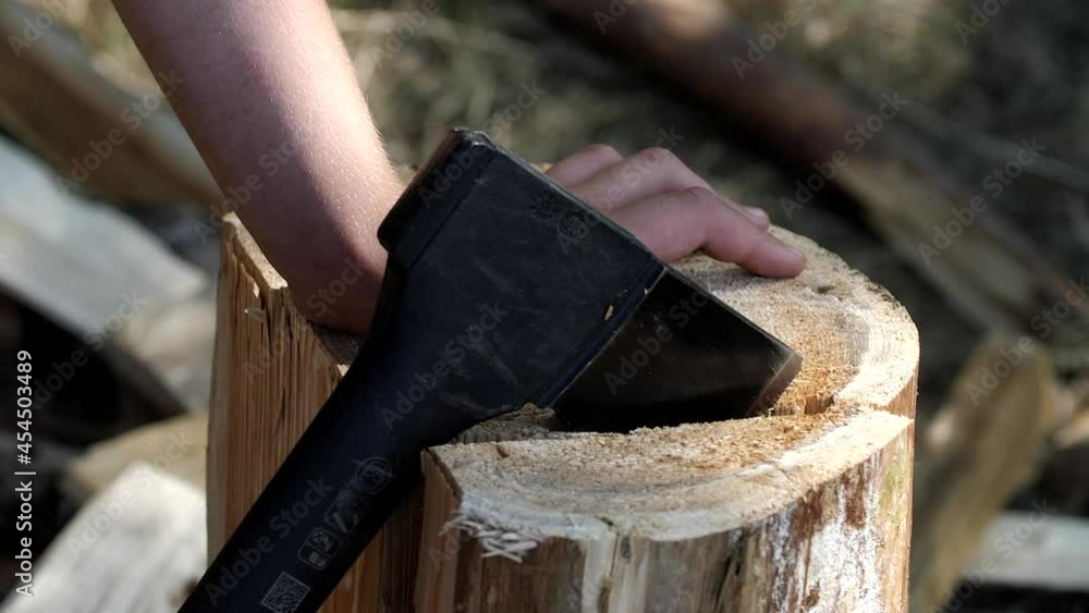 Logging wood. Strong male hands chipping off a piece of log with an ax ...