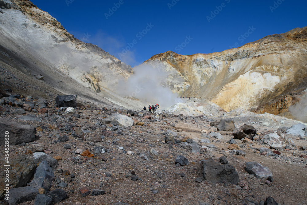 a valley of fumaroles with an eruption of water vapor and sulfur ...