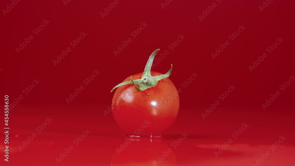 Set of video shots of red ripe tomatoes with green tails falling on wet ...