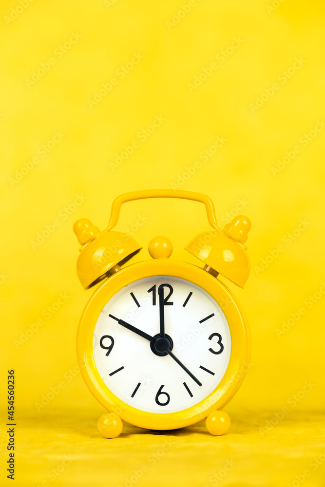 Yellow clock vertical background, save time or daylight savings concept ...