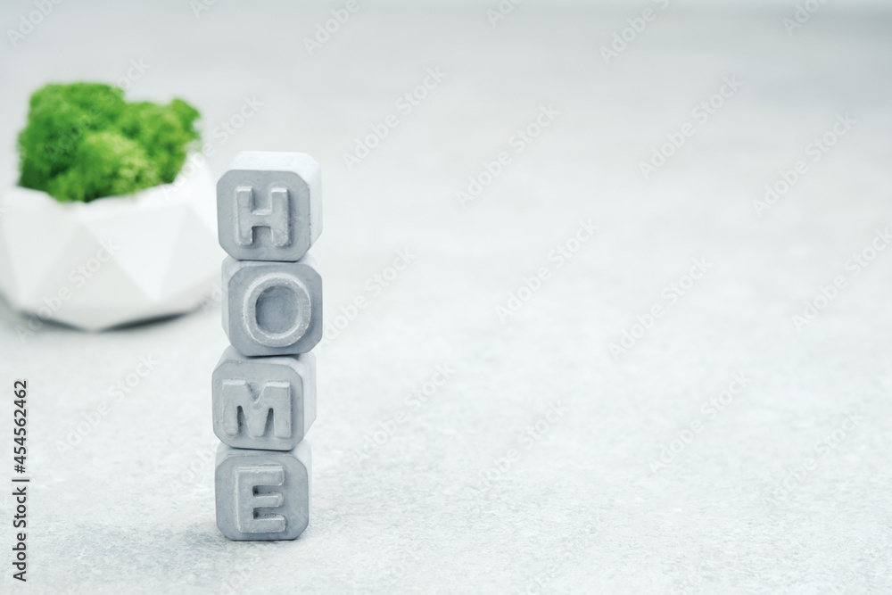 Word Home made from gray concrete letters and pot with green moss ...