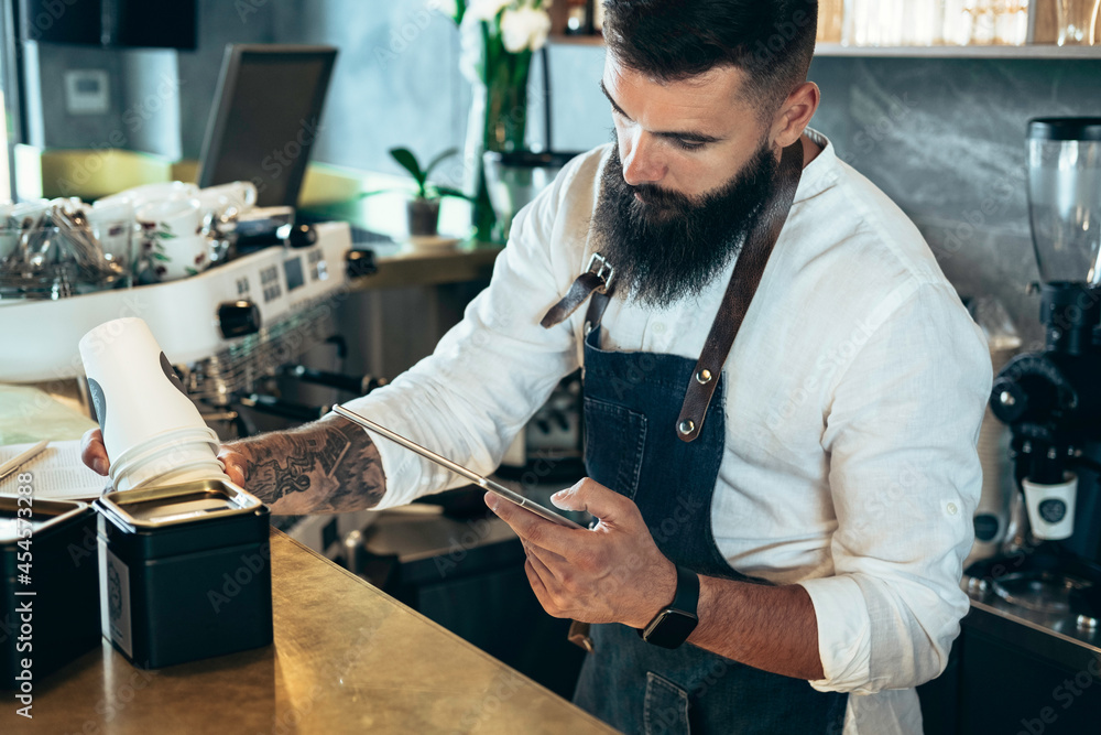 Handsome Barista Doing an Inventory of the Products in a Cafe. Serious ...