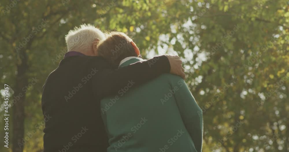 4k Back view of happy lovely caucasian senior couple sitting in bench ...