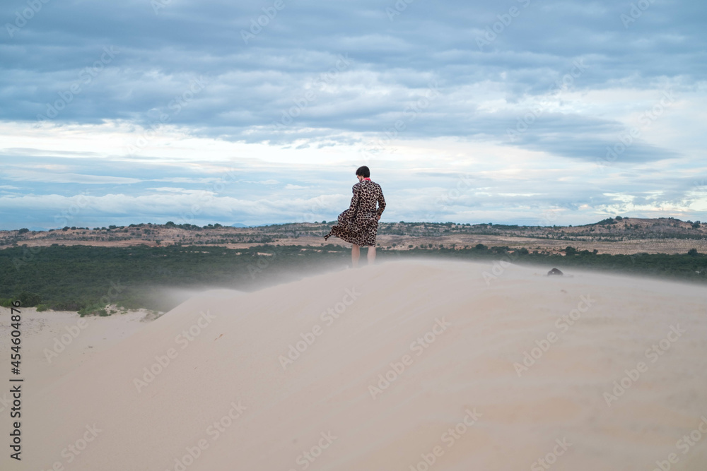 Wanderer walking in the desert. Young man standing in white sand dunes ...