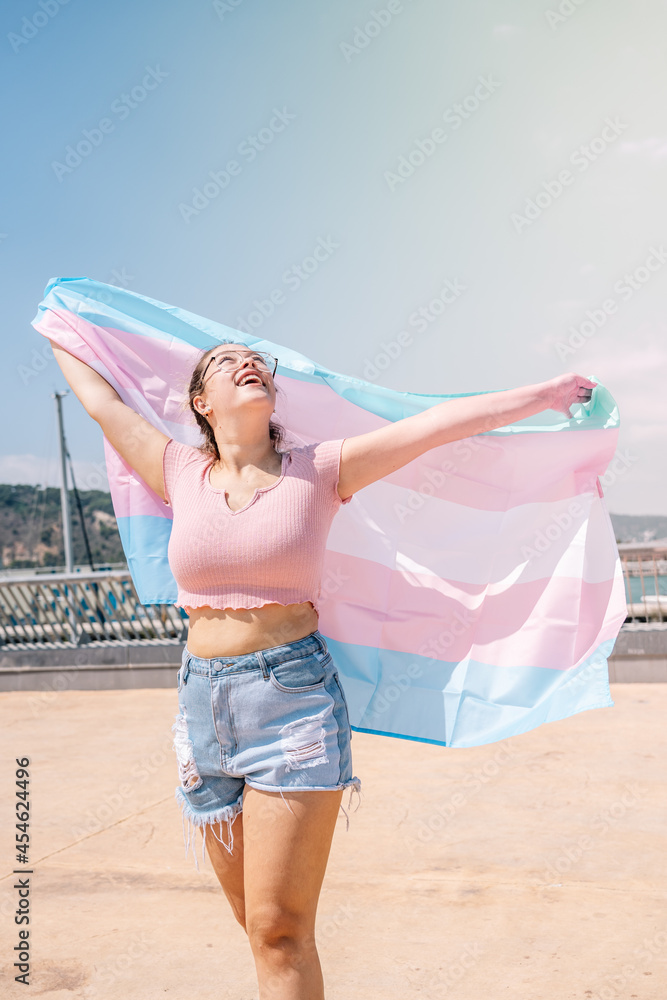transsexual woman with trans flag, holding a transgender pride flag ...