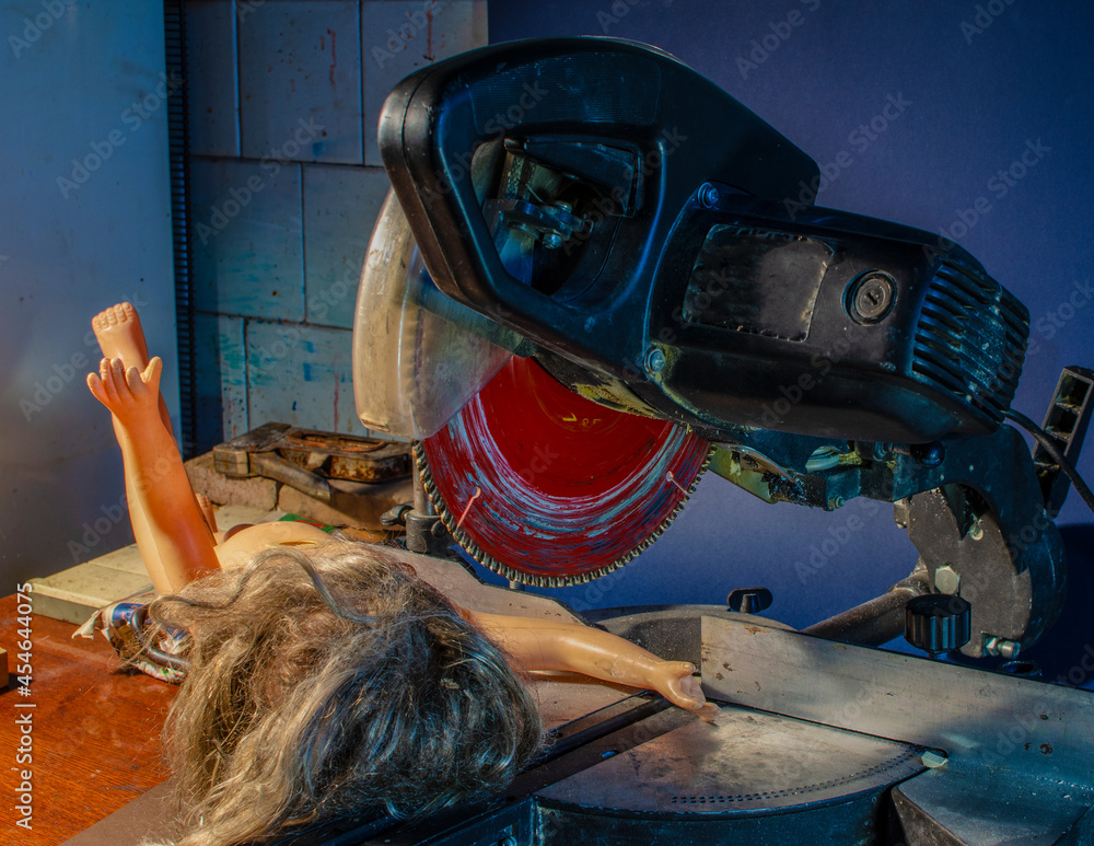 Symbolic amputation of the doll's hand with an electric saw or a ...