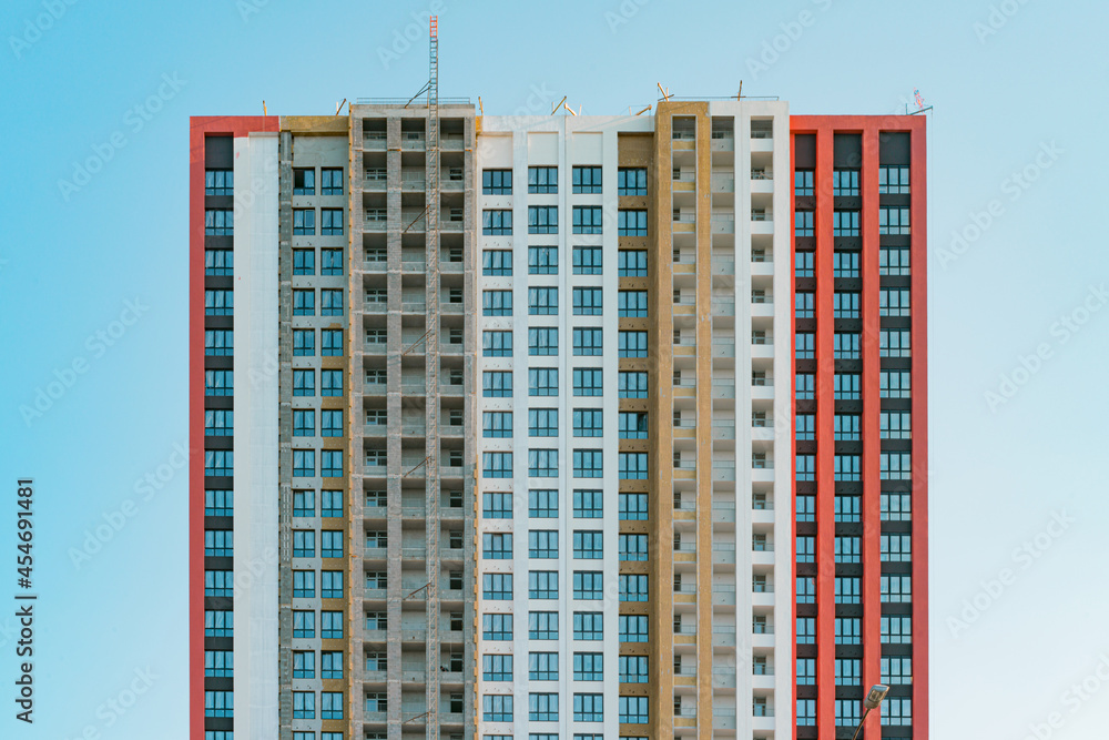 Red, white and black building under construction. Front view of ...