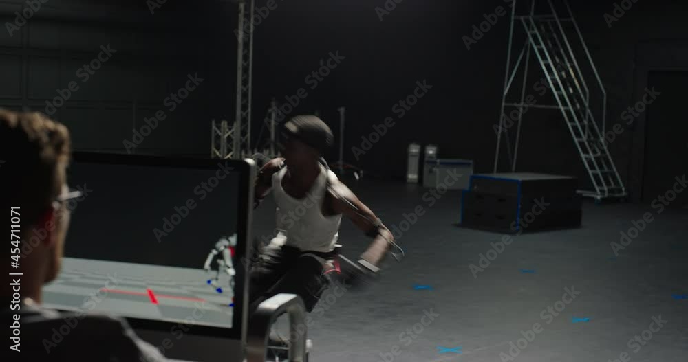 fit man wearing motion capture suit in studio fighting computer gaming ...