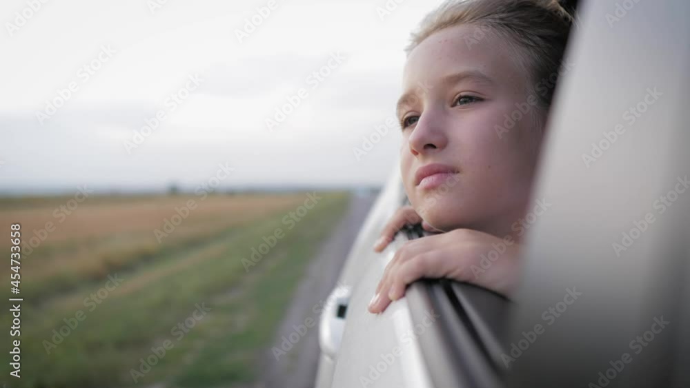 Happy family travel. Little girl leaning out of car window waving hand ...