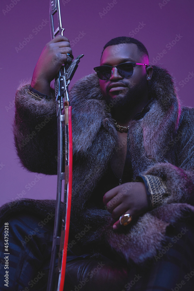 Dangerous black man with sword sitting on armchair Stock Photo | Adobe ...