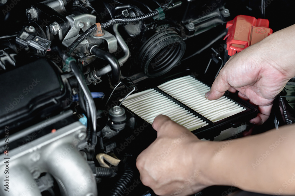 Hand a man input new air filter of car engine in engine room basic ...
