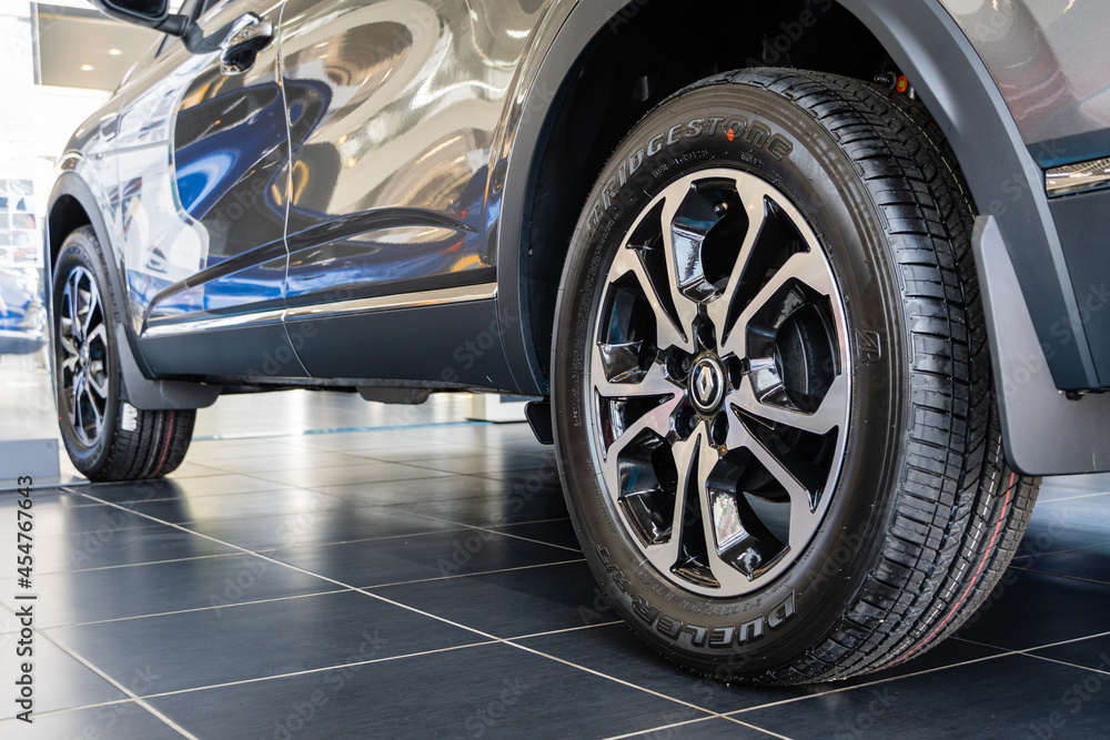 Gray SUV Renault Arkana at the showroom. Bridgestone tire is mounted on ...