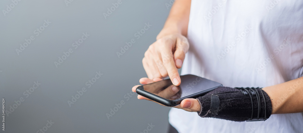 woman holding her wrist pain because using smartphone long time. De ...