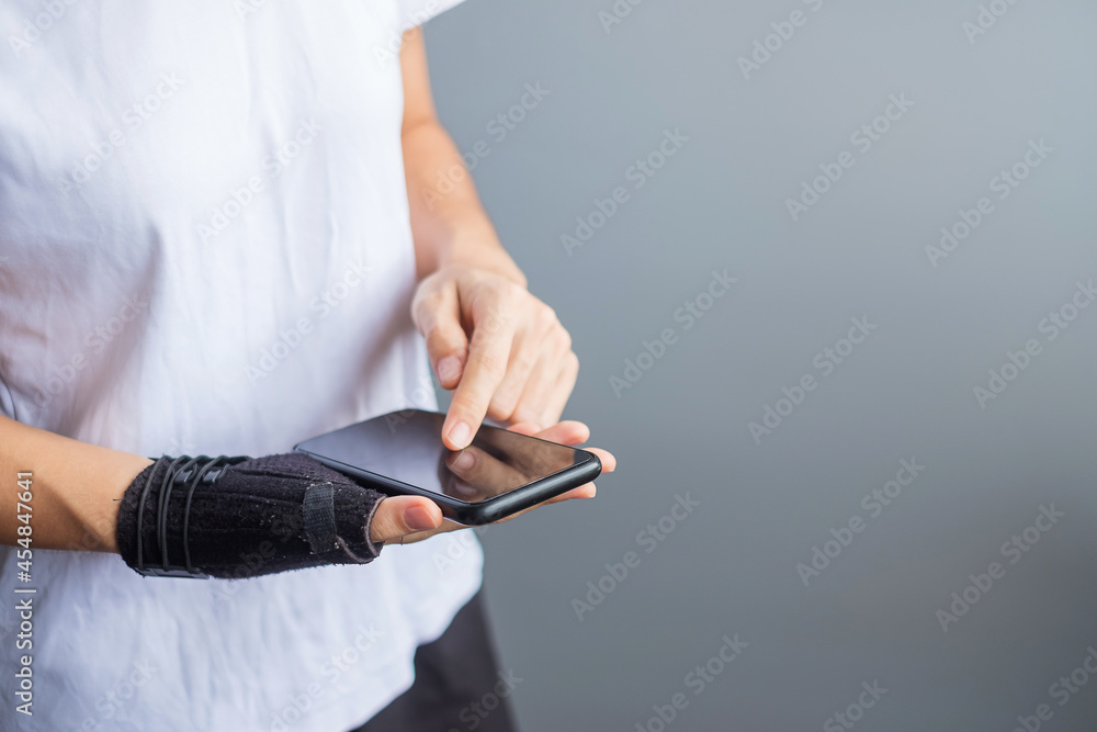 woman holding her wrist pain because using smartphone long time. De ...