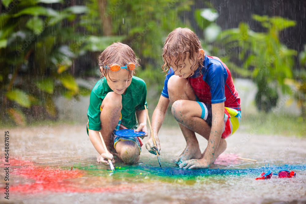 Kids playing in the rain. Chalk drawing fun. Stock Photo | Adobe Stock