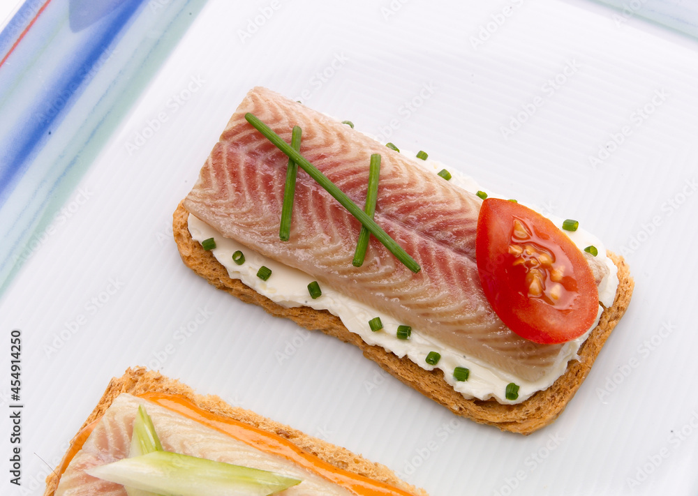 Aperitivo, canapé de pescado ahumado con queso cremoso con tomate y ... Aperitivo, canapé de pescado ahumado con queso cremoso con tomate y ...