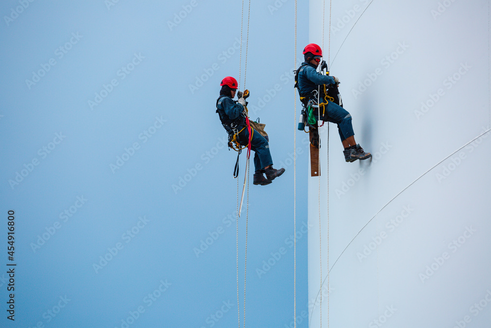 Male two workers down height tank rope access inspection of thickness ...