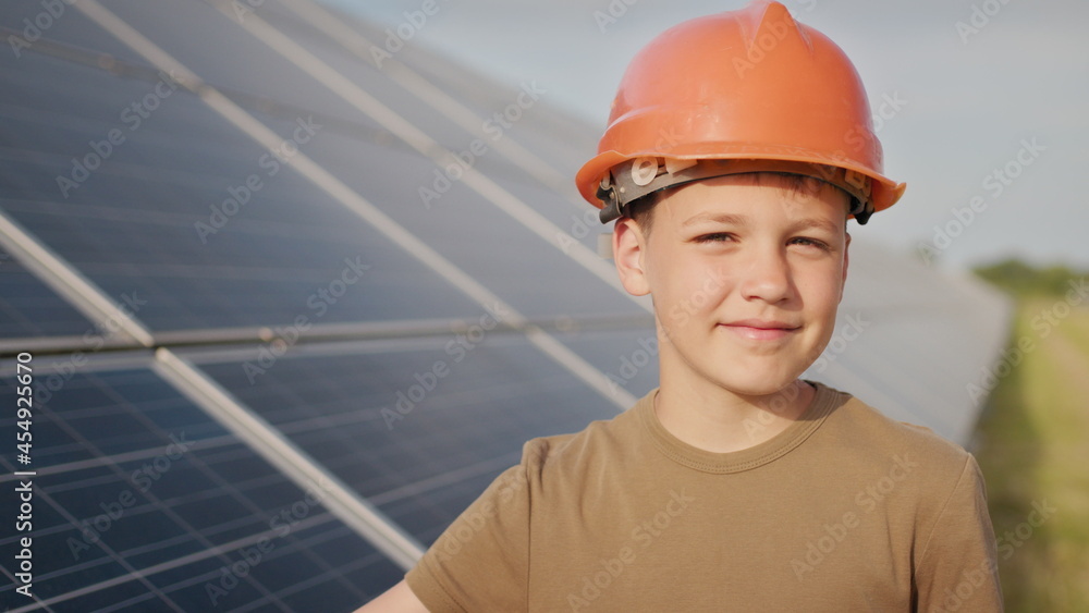 Foto de Little boy in a protective helmet at a solar power plant. The ...