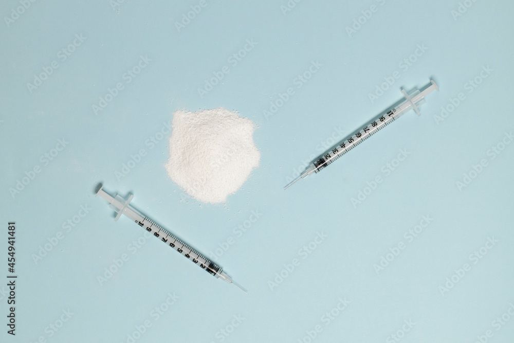 Cocaine or heroin narcotic drug powder and two syringes with a needle ...