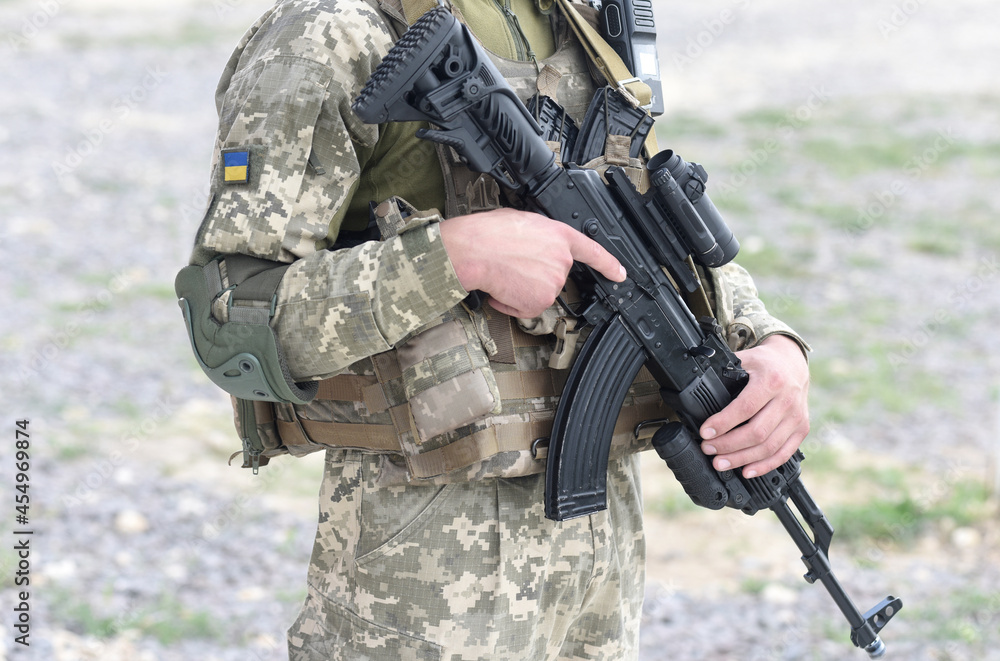 Soldier of Ukraine with assault rifle and flag of Ukraine on military ...