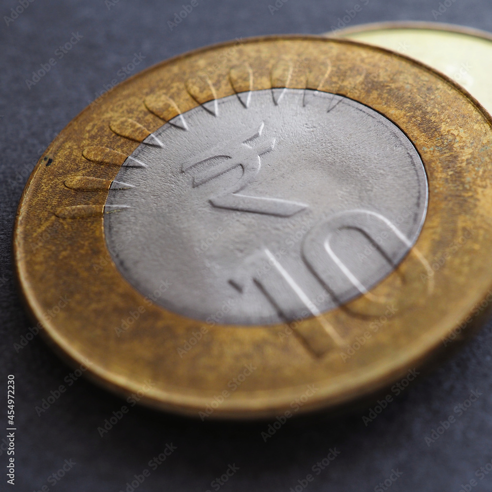 Foto de Two Indian coins lie on a textured surface. 10 rupee coin with ...