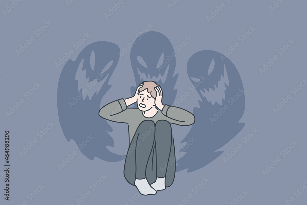 Phobias and inner fears concept. Young stressed man sitting touching ...