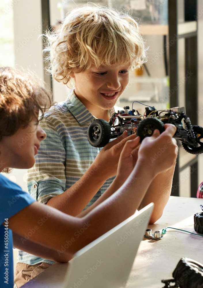 School kids boys helping in building robotic car learning together at ...