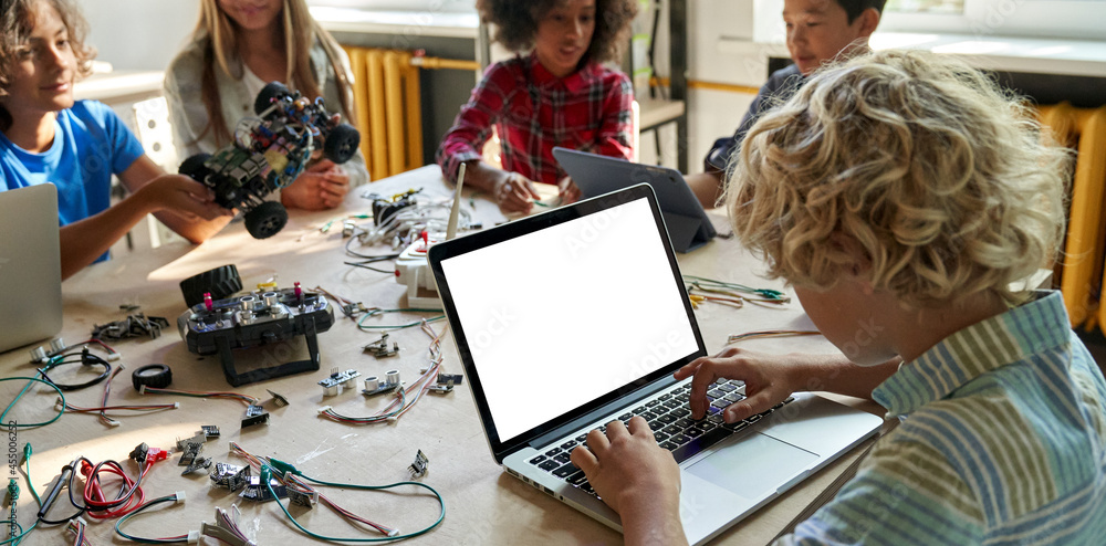 School kid boy using laptop computer with mockup blank empty screen ...