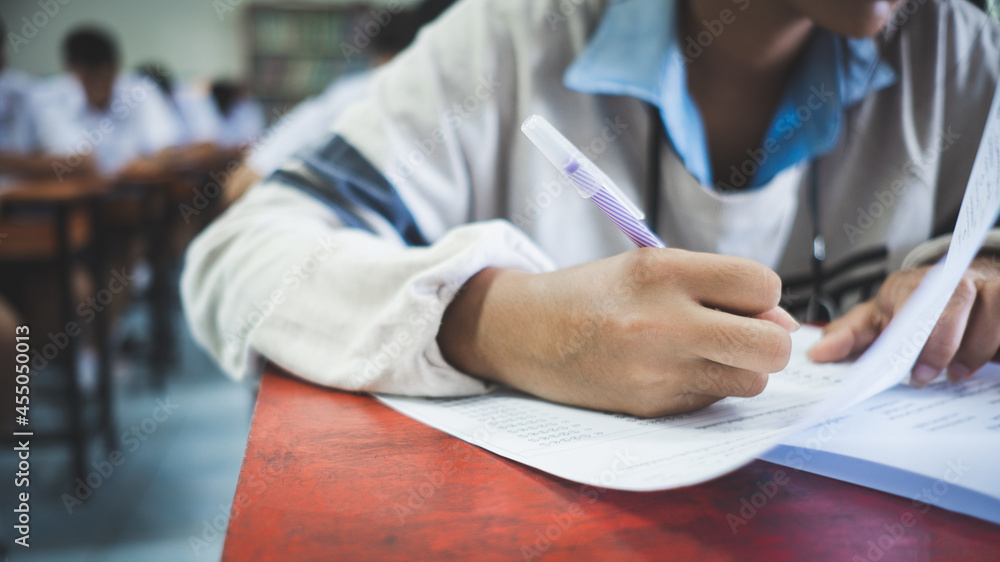 Students writing and reading exam answer sheets exercises in classroom ...