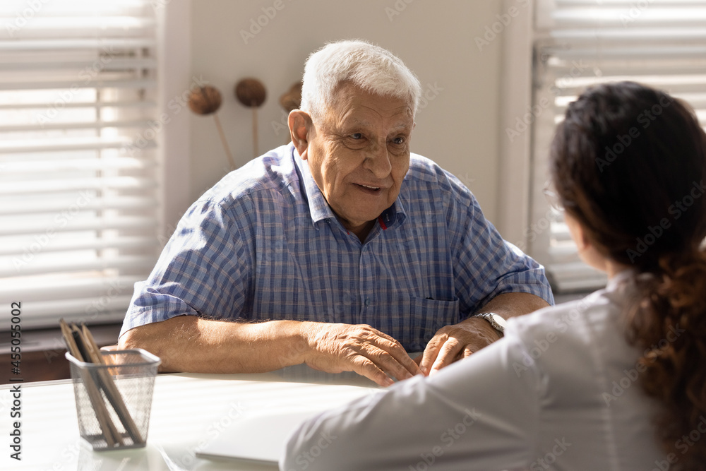 Positive senior 80s patient consulting doctor at appointment, visiting ...