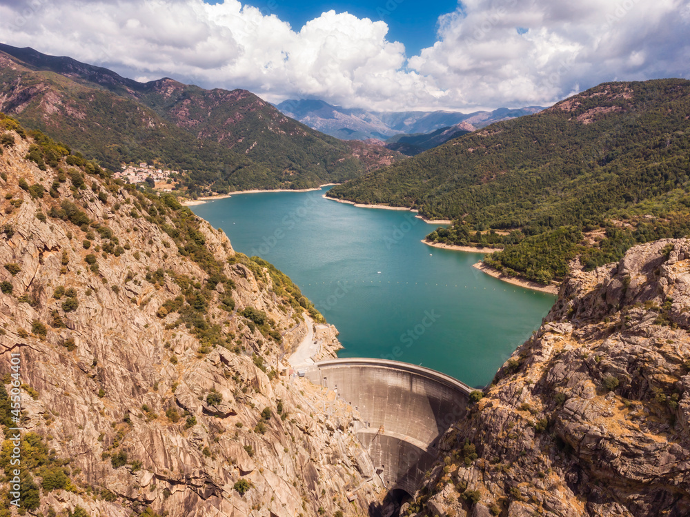 Foto de Aerial view of the dam wall at Lac de Tolla and the village of ...