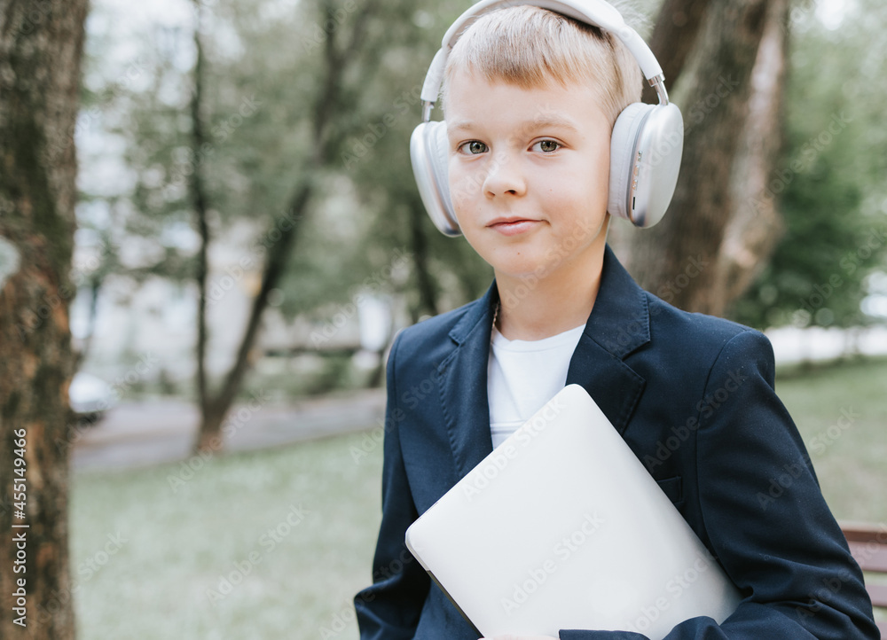 cute schoolboy with backpack in a school uniform with headphones and ...