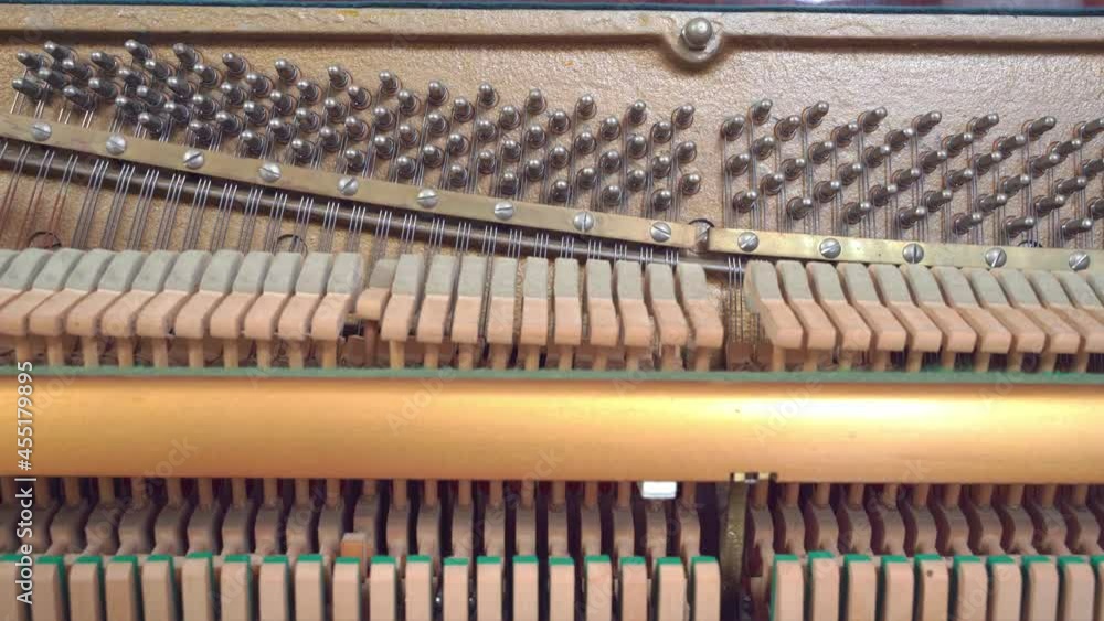 Camera moves along the hammer rail while felted mallets strike strings ...