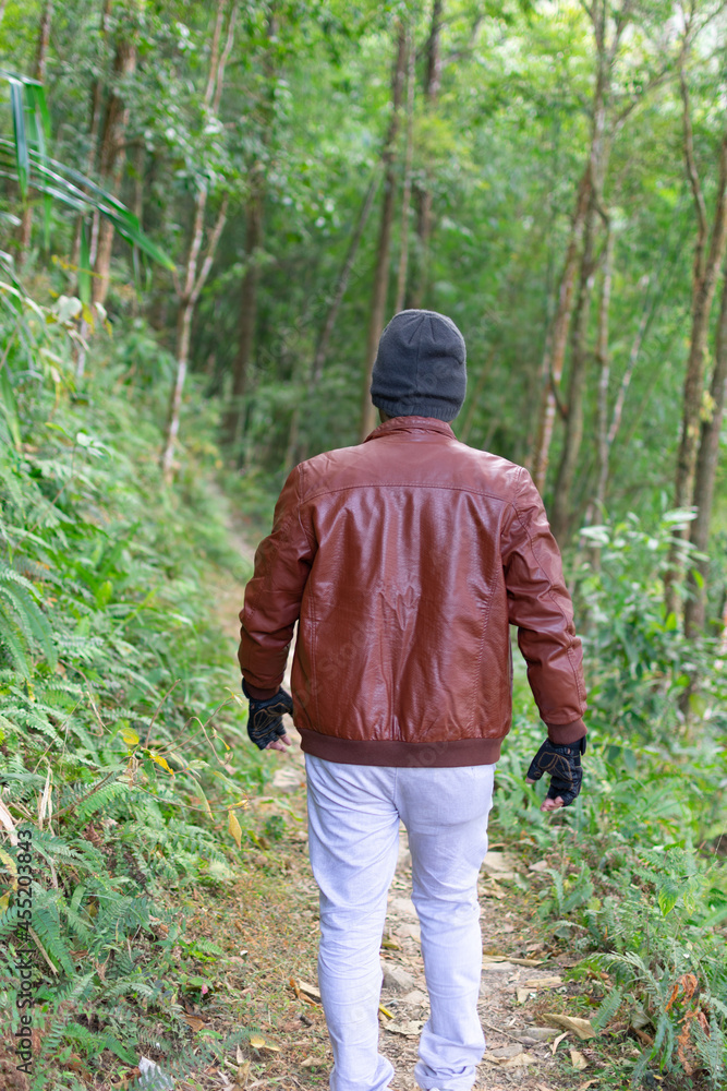 Young Indian man adventures in the deep forest. Man walking in the ...