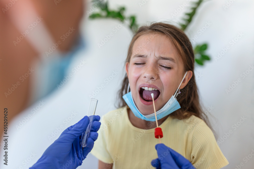 Nurse performing a mouth swab test on a little child. Girl going ...