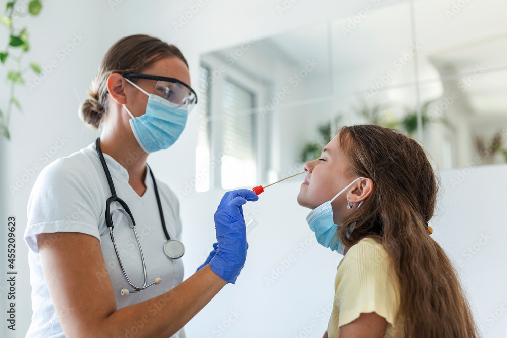 Nurse performing a nose swab test on a little child. Girl going through ...