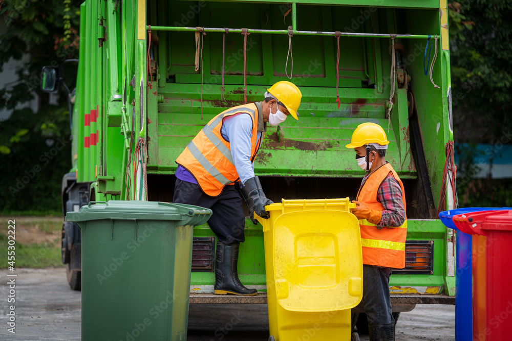 Garbage men working together on emptying dustbins for trash removal ...