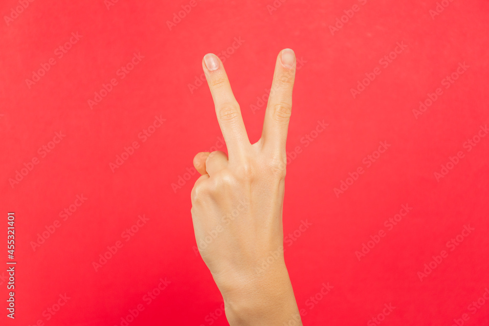 Mano numero 2, señal numero 2, fondo rojo. Stock Photo | Adobe Stock