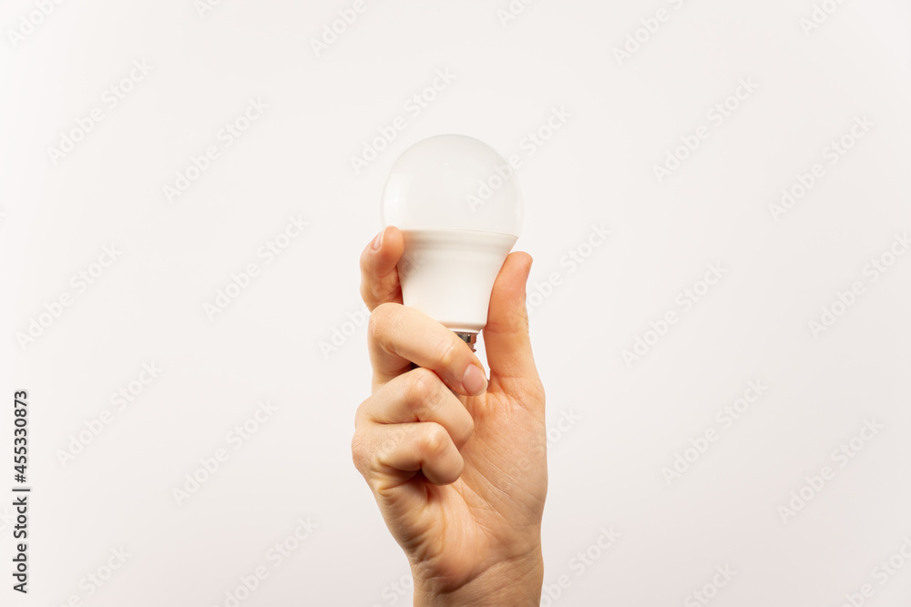 Mano sosteniendo foco, fondo blanco. Stock Photo | Adobe Stock