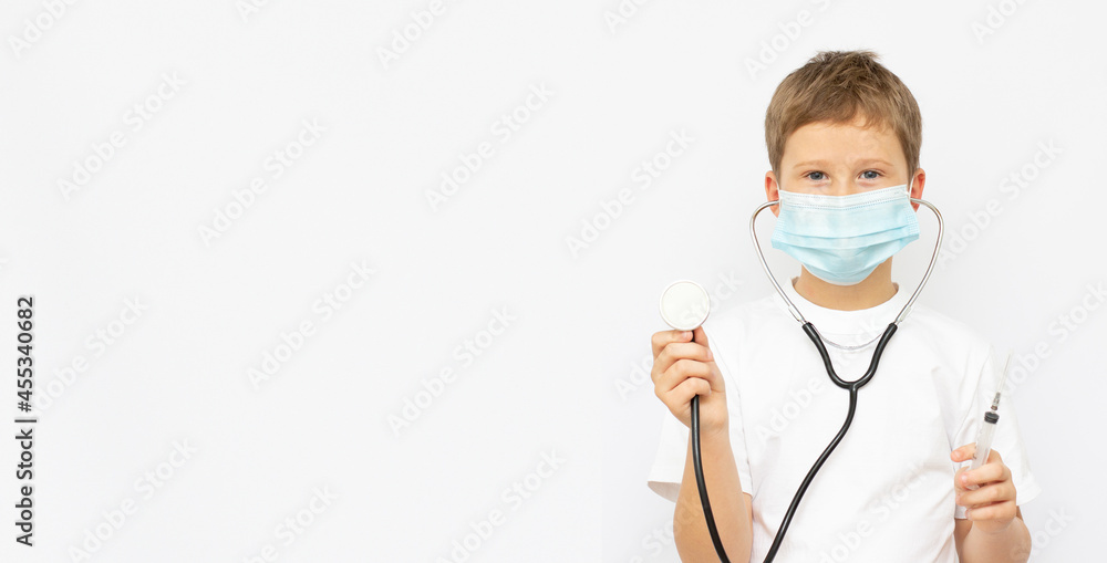 Cute boy doctor wearing medical mask and giving thumbs up isolated on light blue background ...