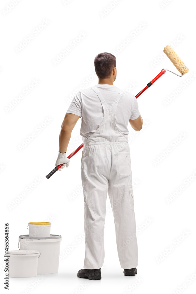 Rear view of a house painter using a paint roller and painting Stock ...