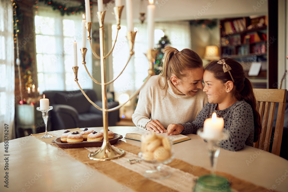 Happy Jewish mother and daughter read Tanakh during Hanukkah at home ...