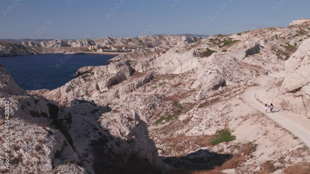 Female Tourists Walk On Trail Through Rugged Landscape In Frioul ...