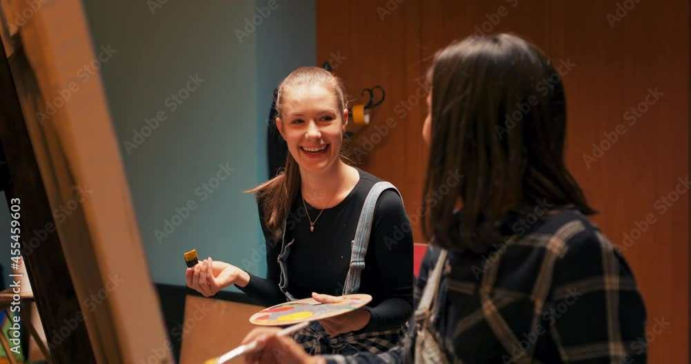 Talented painters painting together a picture from two sides, using ...