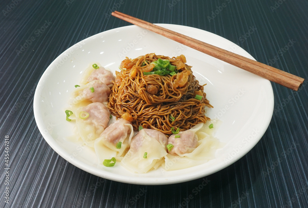 stir fried dry wanton noodle mee with meat dumpling on dark grey wood ...